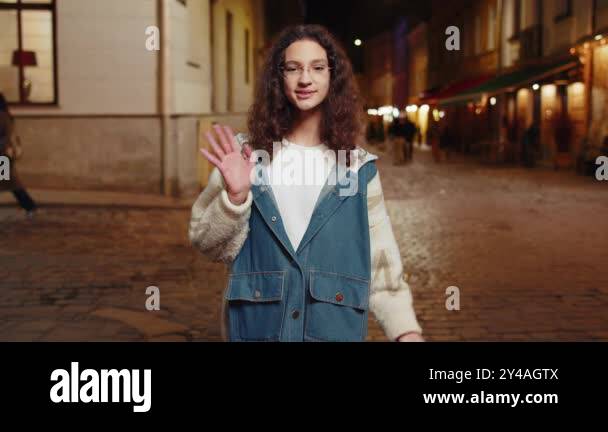 Hello. Teenage girl in casual clothes smiling friendly at camera ...