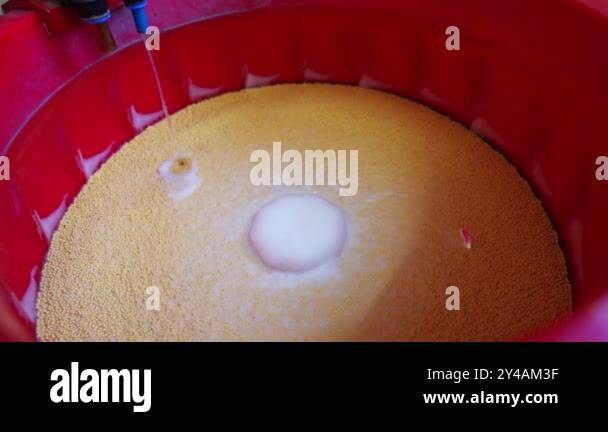 This video shows a close-up of a tumbling machine filled with yellow ...