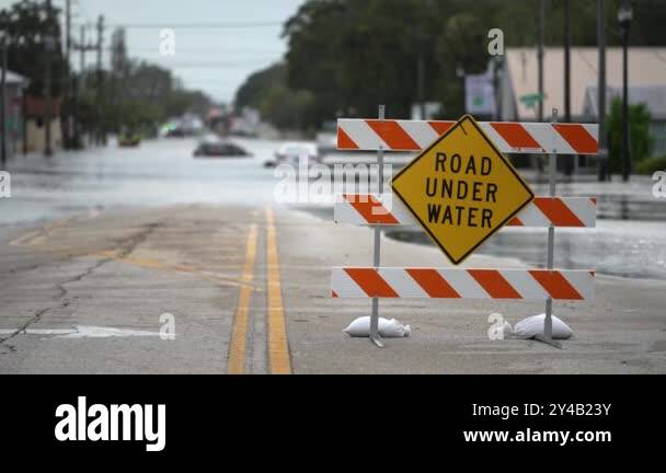 Hurricane Debby flooded street with road closed sign blocking driving ...