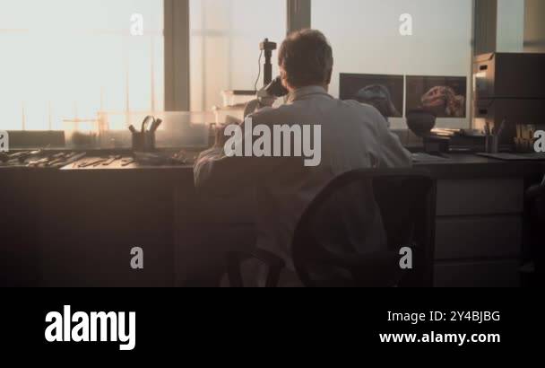 Mature microbiologist analyzes fossil sample under microscope. Bones of ...