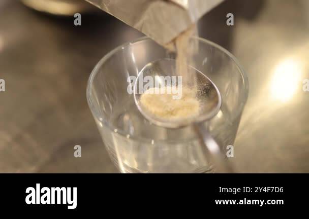 powder pouring, packet spoon, food preparation. Close-up powder being ...