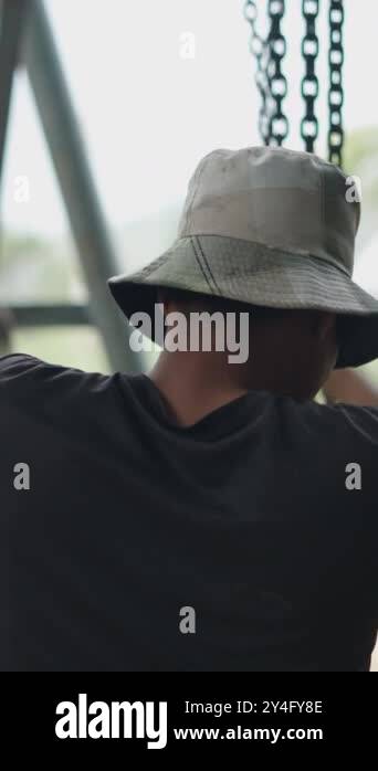 young asian man working as a mechanic pulling a chain to lift an engine ...