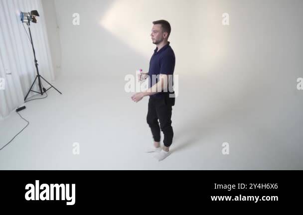 A male model showcases poses and movements in a lively studio ...