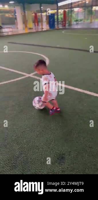 Aceh, Indonesia - August 11, 2024: The kid play ball in field. A kid ...
