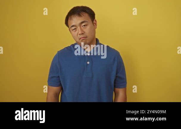 Sad and depressed young chinese man standing with angry and worried ...