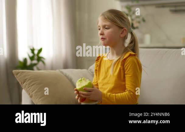 Little European girl bite eat apple baby tooth fell out pain dentistry ...