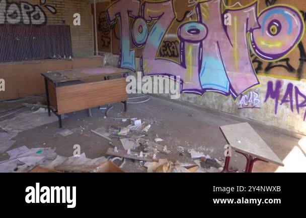 Abandoned classroom in an old school with broken furniture, cracked ...