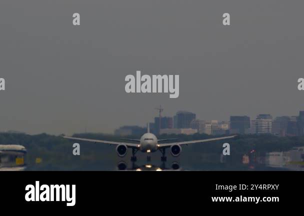A passenger plane taking off from the runway with landing gear still ...
