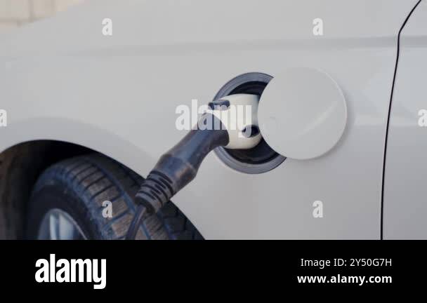 Electric vehicle charging port plugging in car. Electric car recharging ...