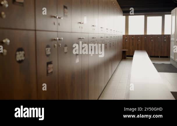 A serene, empty gym locker room featuring rows of closed wooden lockers ... A serene, empty gym locker room featuring rows of closed wooden lockers ...