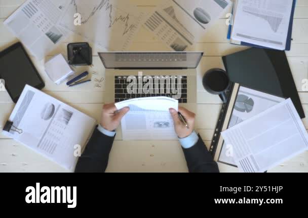 Top view hands of young businessman looking at diagrams with statistic ...