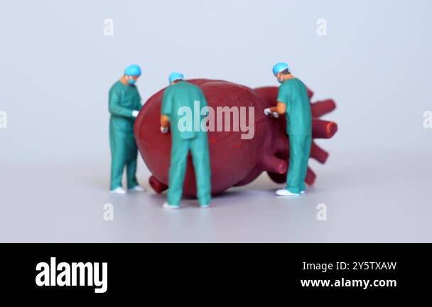Miniature medical team performing surgery on a human heart model ...