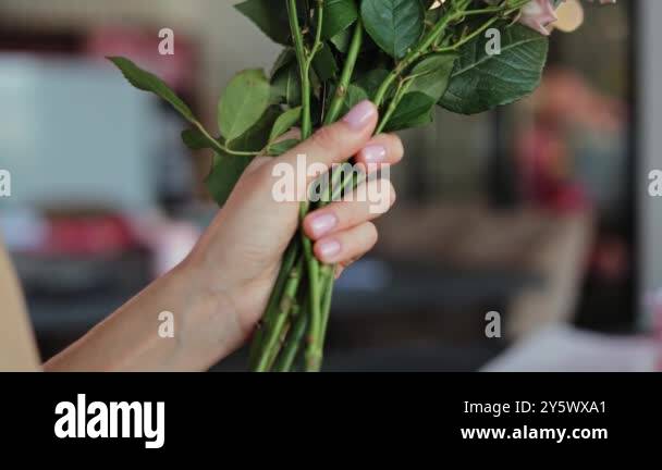 Close up of a florists hands as they delicately arrange the stems of ...