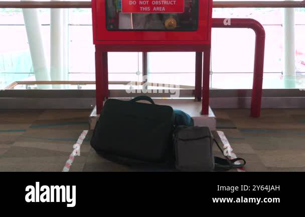 Luggage and personal items placed near warning sign at airport terminal, emphasizing travel and ...