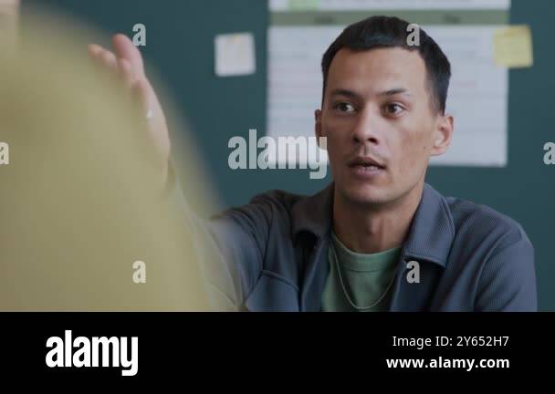 Chest up of Biracial male student speaking to teacher while having ...