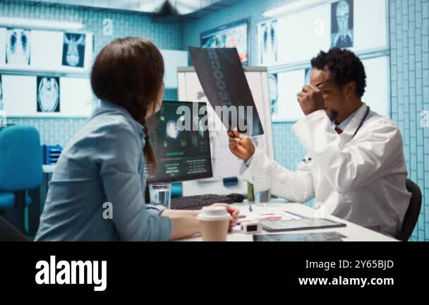 Medic expert showing the x ray imaging test results to patient at check ...