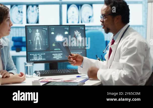 African american physician presenting the x ray diagnostics results to a patient, examining the ...