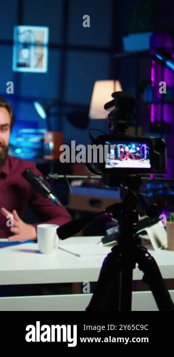 Vertical video Content creator hosting online show in rgb lights studio ...