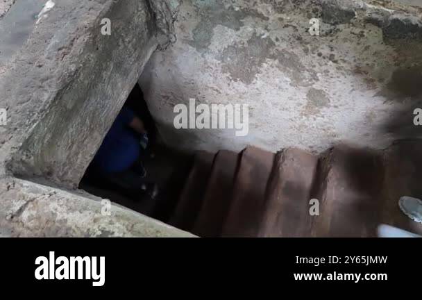 People enter Cu Chi tunnel by step down stairs at tunnels door, tourist ...
