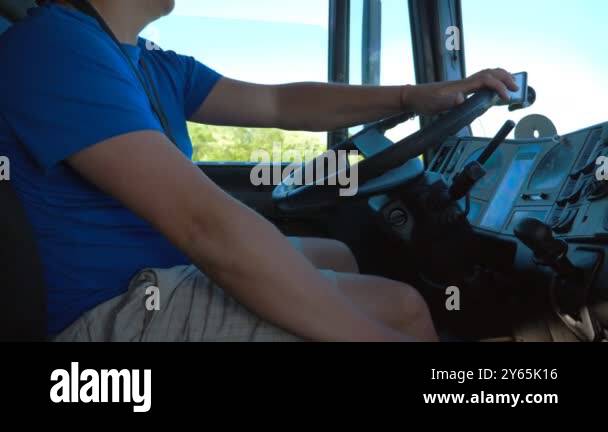 Side view of unrecognizable driver sitting behind steering wheel of his ...