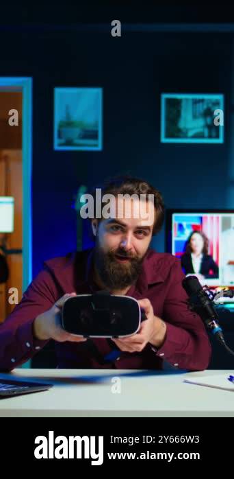 Vertical video Technology specialist reviewing VR goggles in RGB lights ...