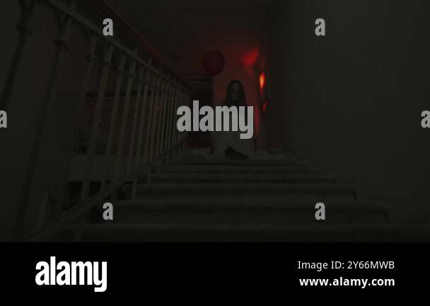 Young female on stairway in darkness. Creepy ghost woman in white dress ...
