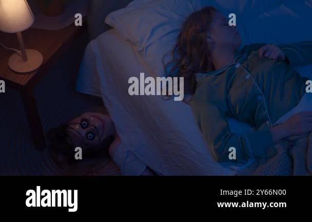 Young female napping at home in darkness. Woman sleeping in bed in dark ...