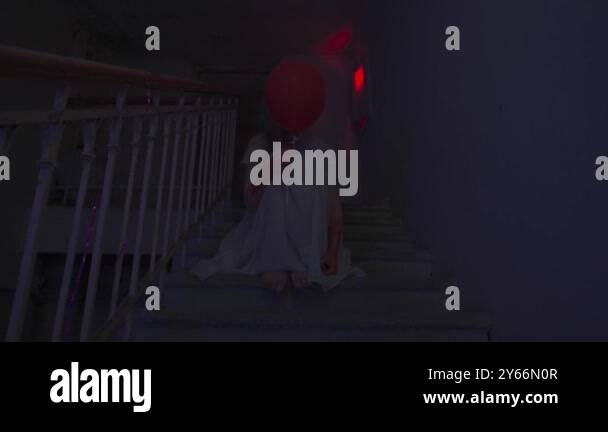 Young female on stairway in darkness. Creepy ghost woman in white dress ...