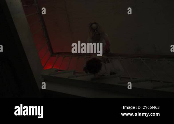 Young female on stairway in darkness. Creepy ghost woman in white dress ...