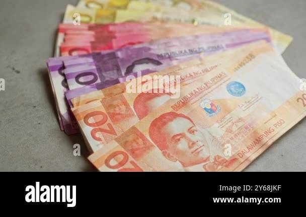 Philippine pesos banknotes scattered on a concrete surface, showcasing ...