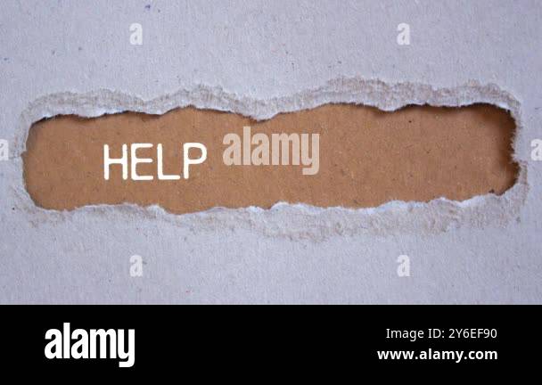 Help is here message writing on ripped torn paper on brown background. Conceptual help is here ...