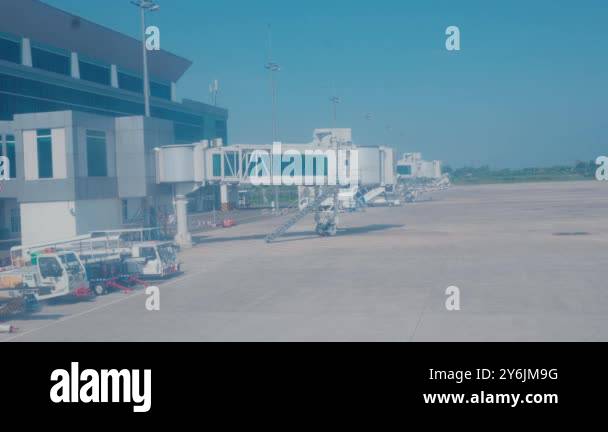 A view of an airport terminal with jet bridges and ground service ...
