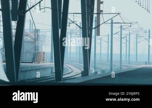 A modern train station platform with sleek architectural supports and ...