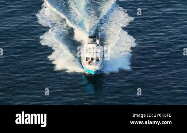 An aerial view captures a fast boat gracefully gliding over the ...
