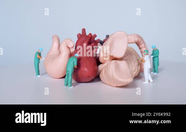 Group of doctor miniatures exploring a pile of huge models of the ...