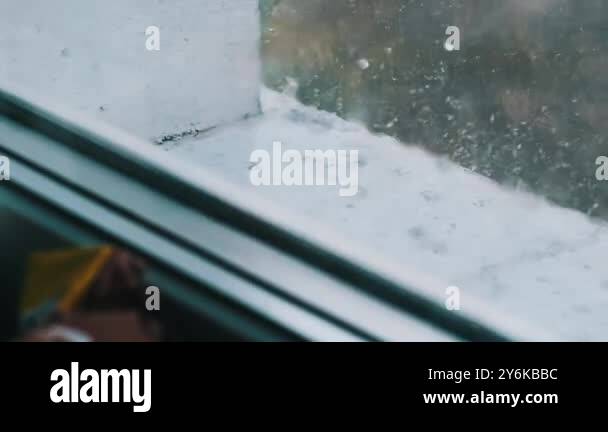 Intense footage of heavy rain and hail seen through a window. The ...