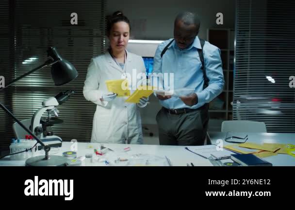 Portrait of Black male detective and biracial female forensic scientist ...