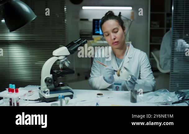 Female forensic scientist in gloves and white coat dusting mug for ...