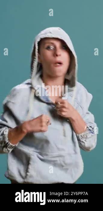 Vertical video Strong bold woman flexing muscles and throwing punches ...