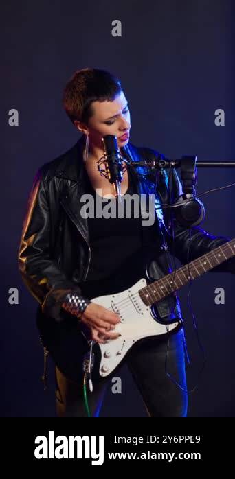 Vertical video Confident female rocker performing live with a bass ...