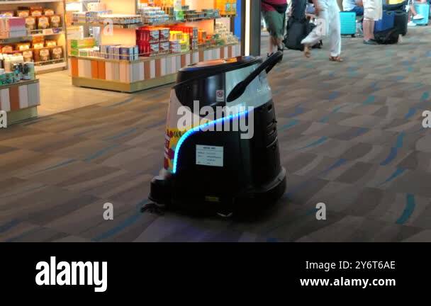 Autonomous cleaning robot vacuuming floor in modern airport terminal ...