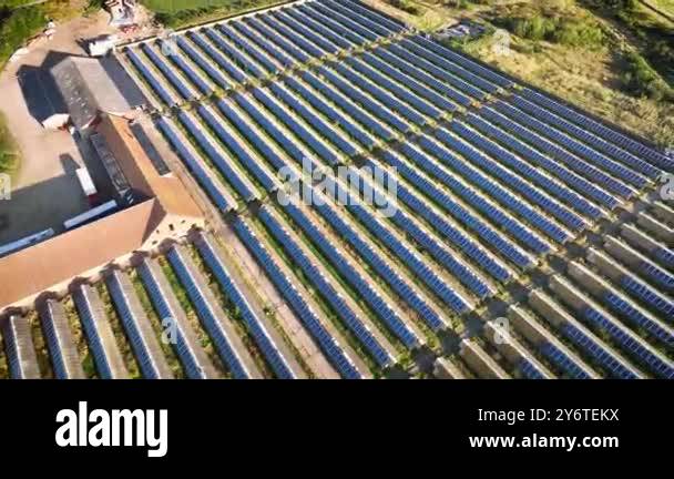 Flying over a solar farm with rows of solar panels installed on the ...