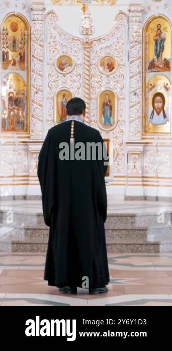 The Iconostasis inside an orthodox church. Video. Rear view of a priest ...