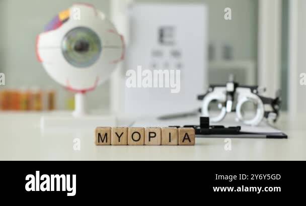 Word Myopia made with wooden cubes in clinic against model of human ...