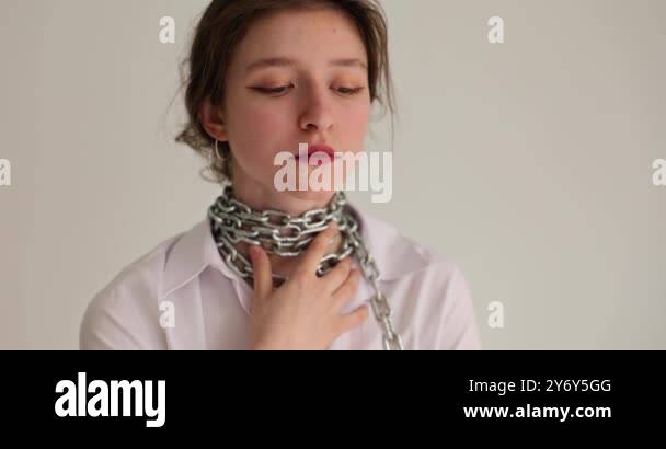 Young woman touches metal chains on throat breathing heavily. Lady with ...
