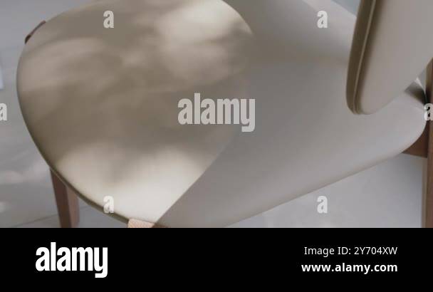 Close-up view of a contemporary white chair with sleek curves and ...
