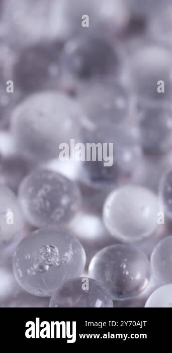 Close-up view of transparent and opaque plastic pellets being examined ...