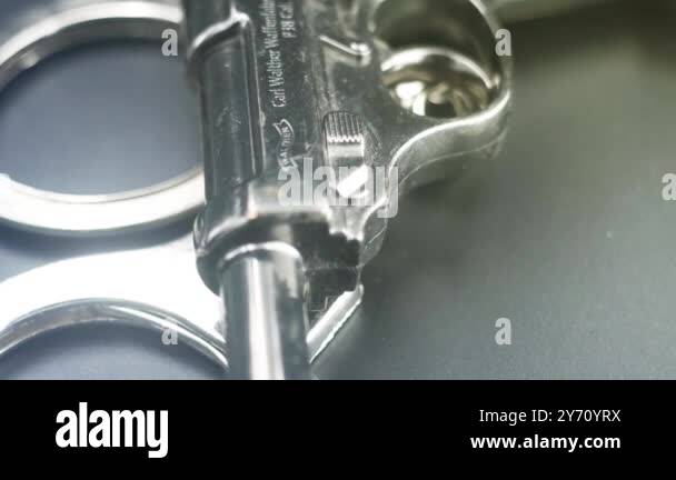 A gun lies on a table - the concept of crime. Spinning close up, the ...