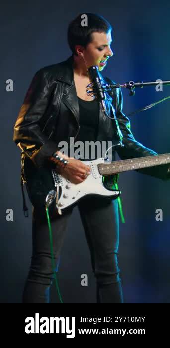 Vertical video Confident female rocker performing live with a bass ...