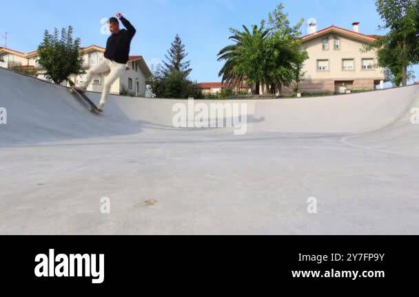 skater skillfully navigates the curves of the bowl at the skate park ...